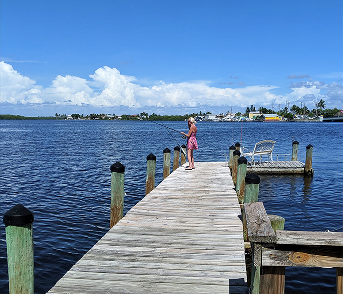 A lone angler casts hopes and dreams from a weathered dock. In Matlacha, fishing isn't just a hobby—it's a meditation. 