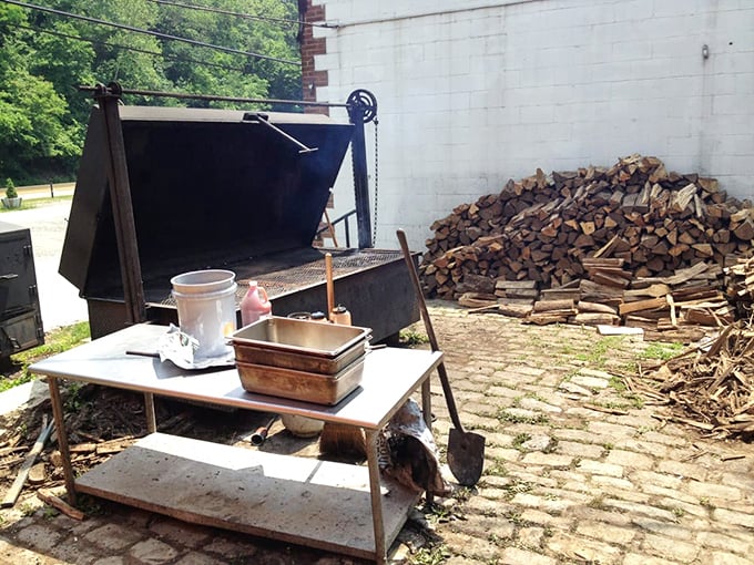The beating heart of the operation—a massive smoker and woodpile that would make a lumberjack weep with joy. This is where patience transforms into flavor.