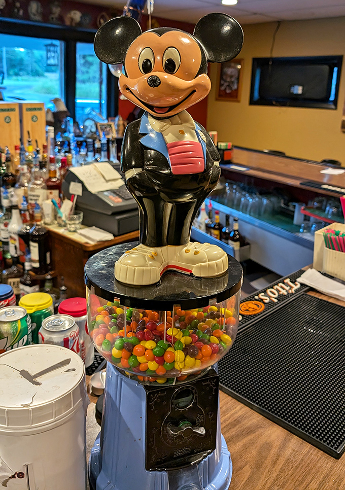 Mickey guards the gumball machine like a whimsical sentinel of childhood joy—a touch of playfulness amid serious dining.