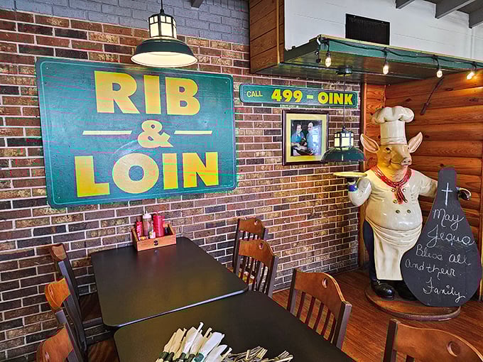 The vintage sign and pig chef statue stand guard over wooden booths. This isn't decoration—it's a declaration that you've entered authentic barbecue territory.