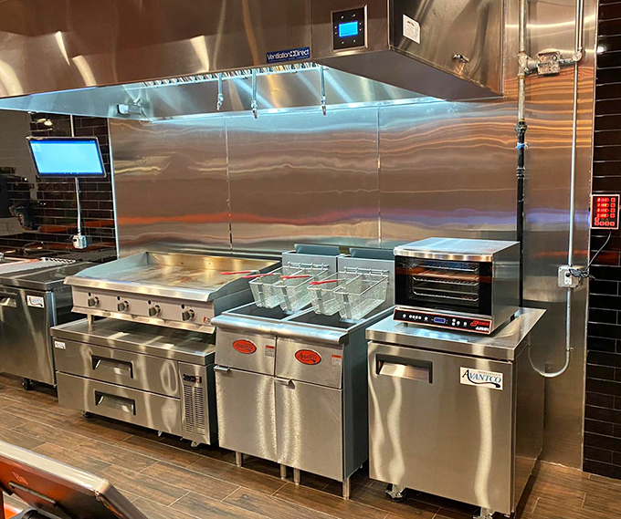 The gleaming kitchen—spotless stainless steel where burger dreams become reality. Like NASA for comfort food.