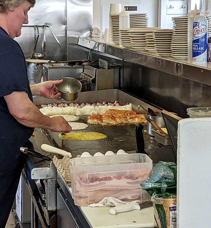 The kitchen ballet—where breakfast magic happens on a well-seasoned grill that's seen more action than an Oregon logging camp.