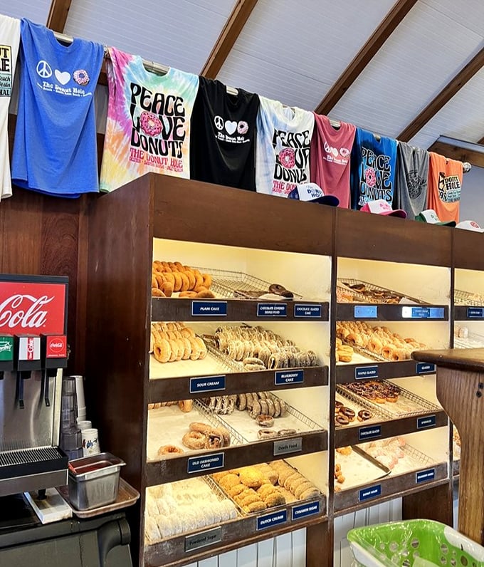 The donut display that launched a thousand diets—and broke them just as quickly. Those "Peace Love Donuts" shirts speak the truth.