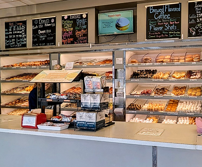 A display case that belongs in the Louvre—rows of donuts arranged with the precision of a Swiss watchmaker and the soul of an artist.