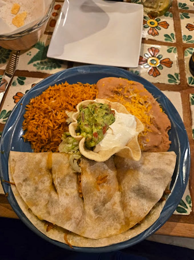 A quesadilla stuffed with tender pork, served with rice, beans, and guacamole in a tortilla cup—proof that sometimes more really is more.