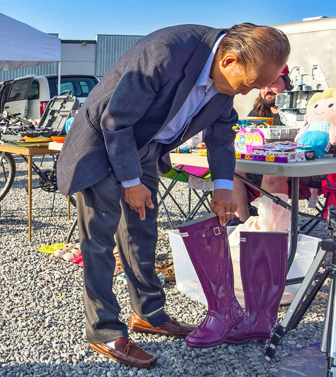 Purple rain boots getting the once-over from a discerning shopper. Perfect for splashing through puddles with considerably more style than practicality requires.