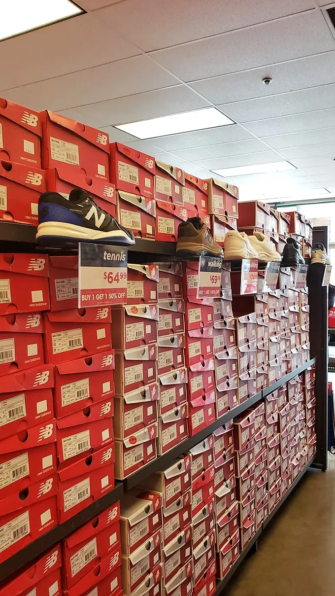 The wall of New Balance possibilities stands like a monument to practical indulgence, each box promising comfort without the usual premium price tag.