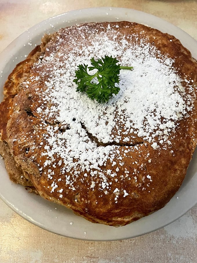 A short stack at Mickey's is anything but short—dusted with powdered sugar and garnished with a sprig of parsley, because even pancakes deserve a corsage.