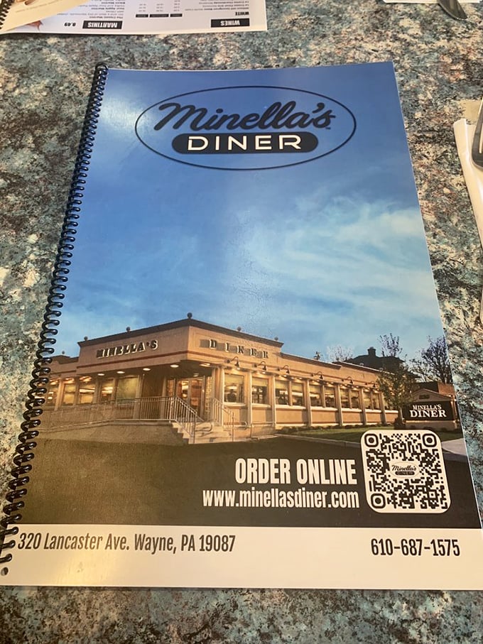 The spiral-bound menu doubles as a photo album of the diner itself—a reminder that you're participating in a community tradition.
