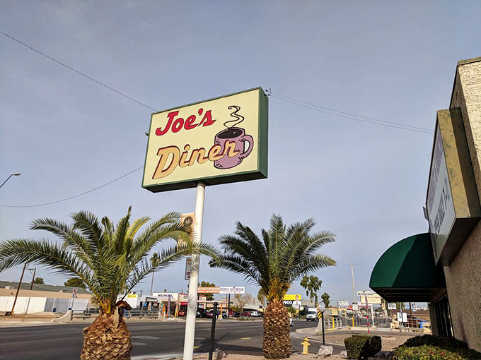 The vintage sign stands tall among palm trees, a retro promise of comfort food that's weathered decades of dining trends.