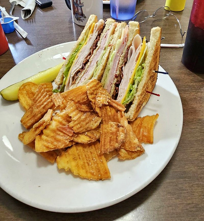 The club sandwich—architectural marvel of the lunch menu. Three stories of deliciousness held together by those fancy toothpicks you're definitely keeping.