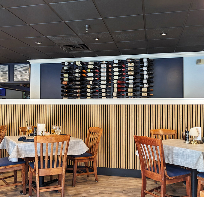 The wine wall stands like a liquid library—each bottle a story waiting to complement your seafood adventure.