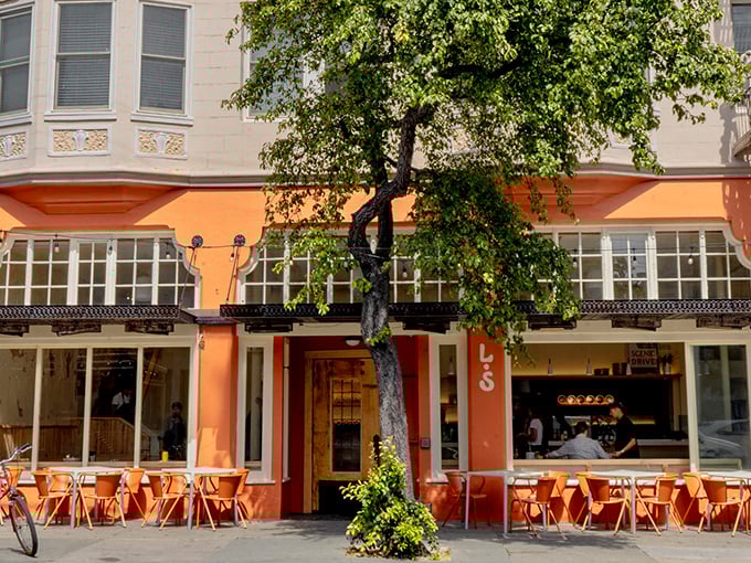 The elegant orange facade and sidewalk seating whisper "sophisticated neighborhood gem" to those lucky enough to discover it.