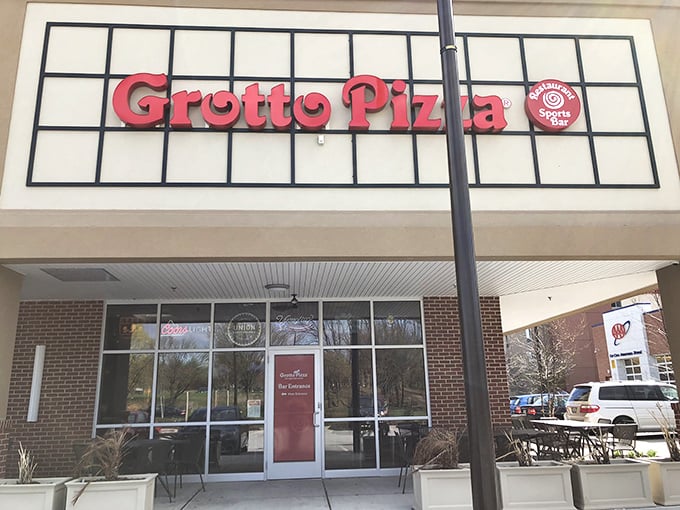 The distinctive Grotto Pizza sign promises their famous swirl pattern inside – pizza with a signature as unique as yours.