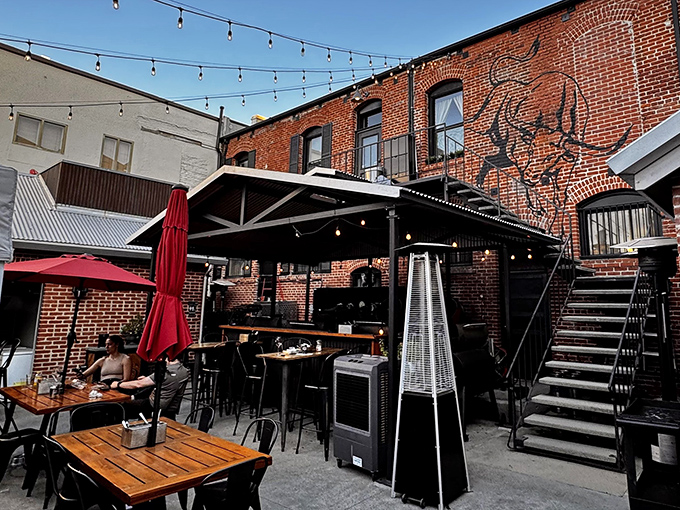 The brick-lined courtyard whispers promises of smoky treasures, where string lights dance above tables awaiting barbecue bliss.