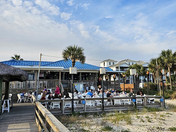 The Blue Parrot's iconic blue roof and weathered wooden deck create that perfect "I've finally arrived at vacation" feeling as diners gather by the Gulf.