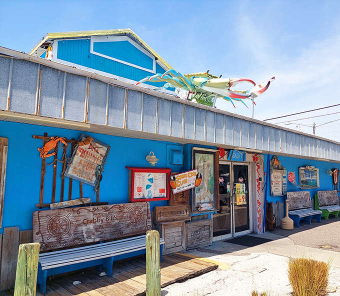 The iconic blue and yellow exterior of Crabby Bill's stands like a cheerful sentinel against Florida's perfect sky, promising seafood treasures within.