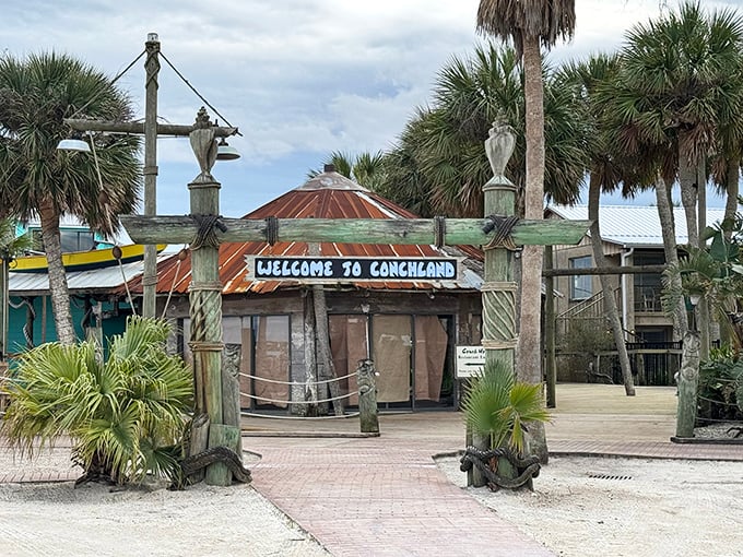 The weathered wooden entrance to "Conchland" promises a tropical escape that's more authentic Florida than tourist brochure—palm trees included, pretension not.