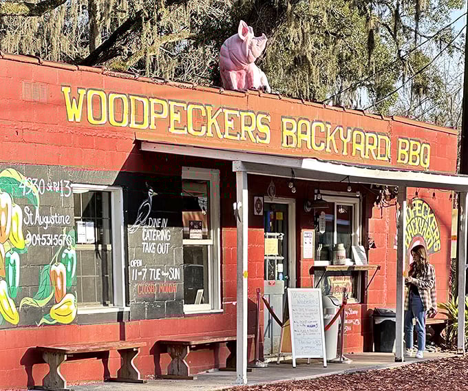 The pink pig perched atop this unassuming red building isn't just decoration—it's a beacon calling hungry souls to barbecue salvation.