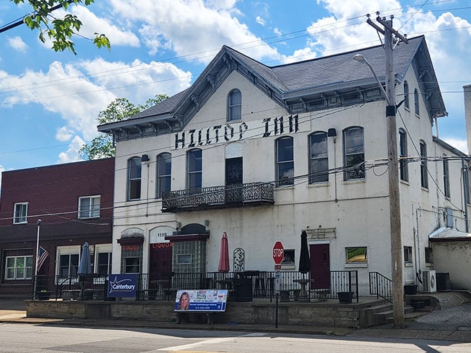 The historic Hilltop Inn stands proudly against an Indiana sky, its weathered white facade telling stories of countless meals and memories since 1837.