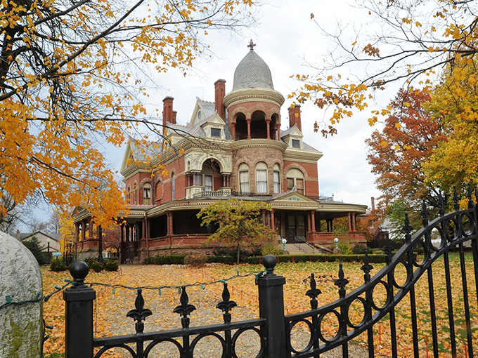 The Seiberling Mansion in autumn glory looks like it's auditioning for a Wes Anderson film—Victorian splendor framed by golden leaves and wrought iron elegance.