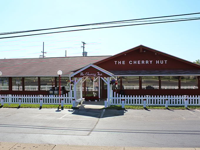 The Cherry Hut's bright red exterior and white picket fence aren't just charming—they're practically sending smoke signals to your sweet tooth from miles away.
