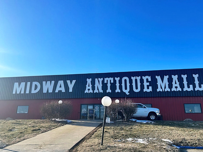 The red barn exterior of Midway Antique Mall stands like a treasure chest waiting to be opened, promising adventures in nostalgia just beyond those doors.