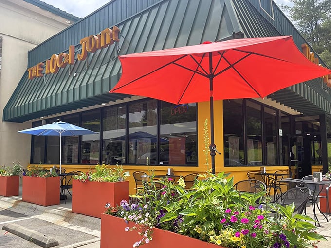 The Local Joint's vibrant exterior welcomes hungry travelers with colorful planters and cheerful umbrellas – breakfast paradise found!