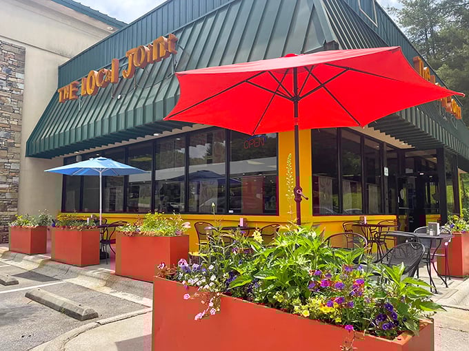 The Local Joint's cheerful exterior with vibrant planters and colorful umbrellas promises the kind of breakfast experience worth setting your alarm for.