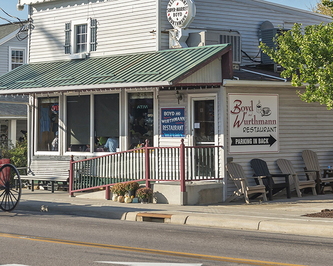 The unassuming white exterior of Boyd & Wurthmann belies the culinary treasures within. Those rocking chairs aren't just decoration—they're time machines to a simpler era.