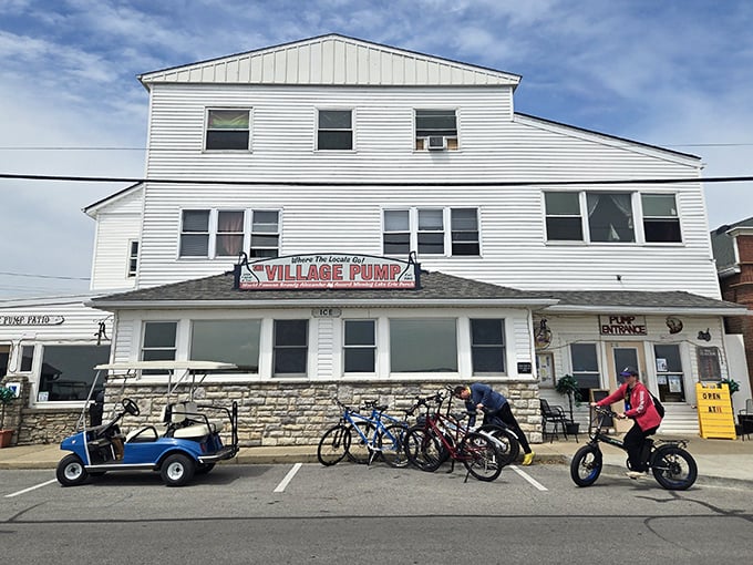 The white clapboard exterior of The Village Pump stands like a beacon of culinary promise on Kelleys Island, golf carts parked expectantly outside.