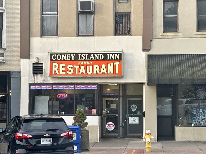 The iconic Coney Island Inn sign beckons hungry travelers like a neon lighthouse guiding ships to the harbor of comfort food.