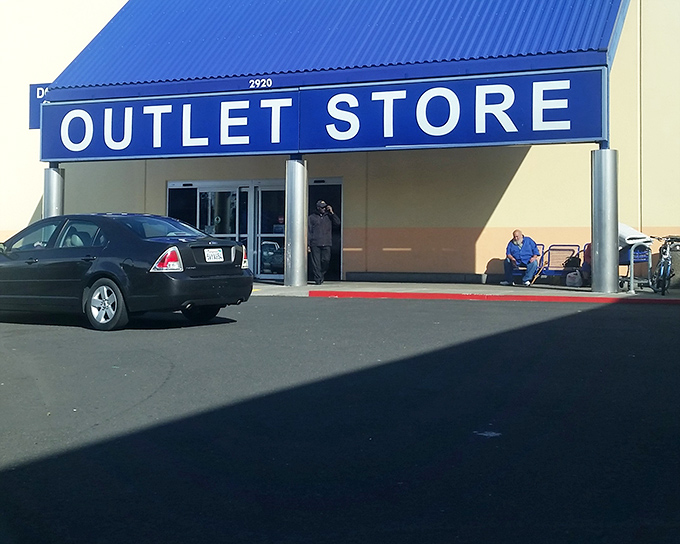The blue-roofed bargain paradise beckons with its simple "OUTLET STORE" sign—a siren call to treasure hunters everywhere.