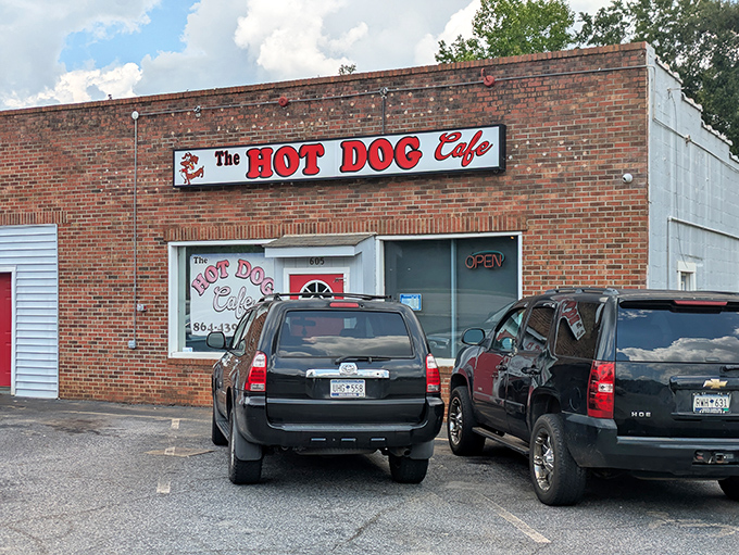 The bright red door of The Hot Dog Cafe beckons like a culinary lighthouse in Wellford, promising comfort food treasures behind that unassuming brick facade.