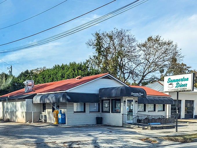The unassuming white exterior with classic blue awnings promises what every great roadside discovery should: authenticity without pretension.