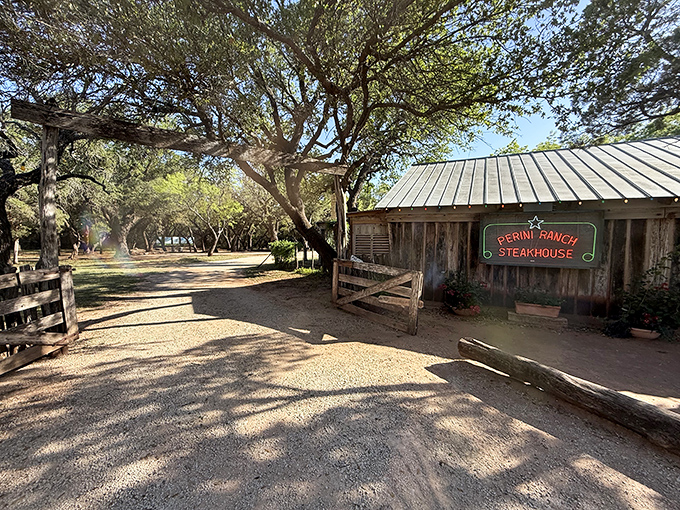 The entrance to paradise isn't pearly gates – it's a weathered wooden sign and gravel path leading to Texas beef nirvana.