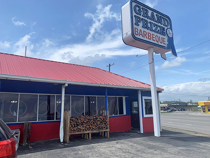 That iconic red roof and blue trim announces you've arrived at barbecue heaven. The woodpile isn't decoration—it's a promise.