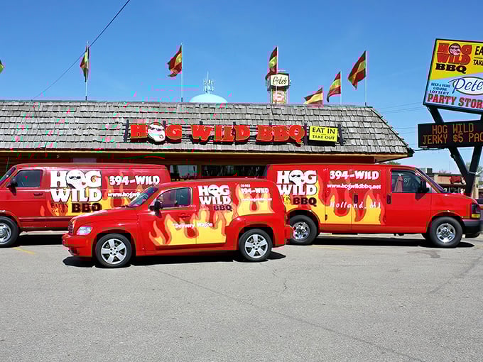 The flame-adorned fleet of Hog Wild BBQ vehicles stands ready outside their Holland headquarters, like a barbecue cavalry prepared for delicious deployment.