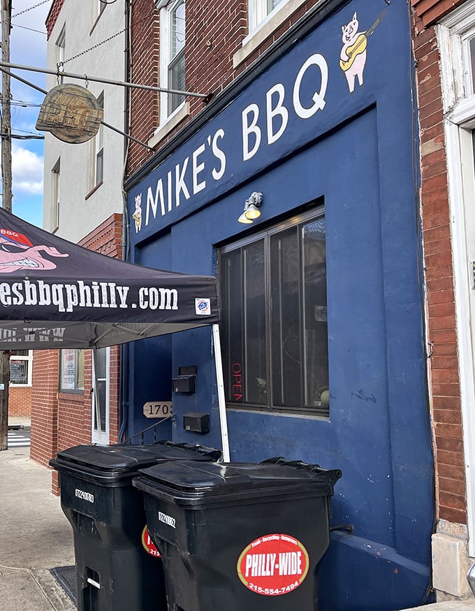 The blue storefront with its playful pig logo promises smoky delights within. South Philly's barbecue gem hides in plain sight.