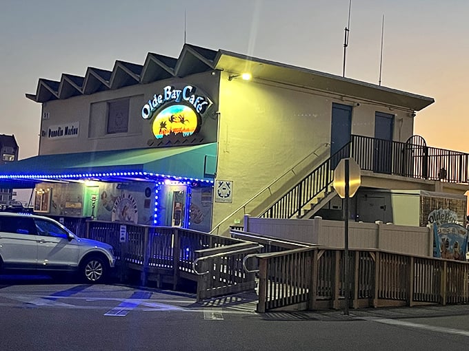The neon-lit exterior of Olde Bay Café glows like a maritime lighthouse, beckoning hungry sailors and landlubbers alike to Dunedin's waterfront treasure.