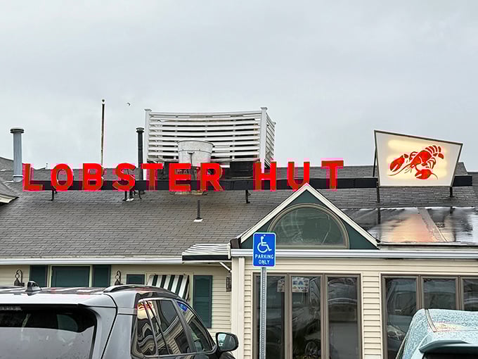 Those iconic red letters against the sky say it all – seafood paradise awaits beneath that humble roof in Plymouth Harbor.