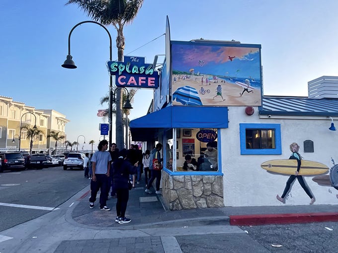 The iconic blue-trimmed exterior of Splash Café, where beach-themed murals and perpetual lines of hungry pilgrims signal you've arrived at chowder paradise.