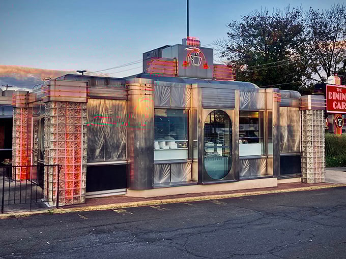 The Dining Car's gleaming stainless steel exterior glows at sunset, a beacon of comfort food promising that everything inside will taste like childhood memories.