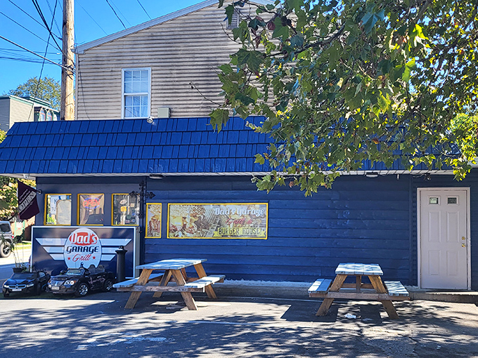 The blue exterior of Dad's Garage beckons like a culinary lighthouse, complete with kid-sized cars that promise this isn't your average burger joint.