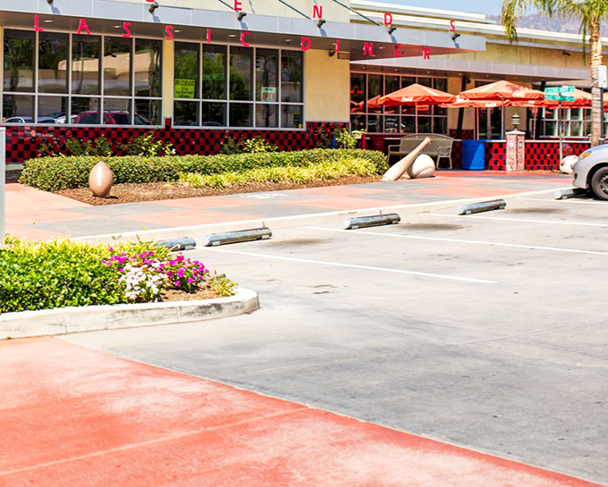 The classic exterior of Legends beckons with its vibrant landscaping and inviting red umbrellas—a time capsule of Americana waiting in Glendora.