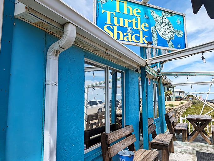 Rustic wooden benches welcome hungry travelers to this coastal gem, where the ocean breeze carries promises of fresh-caught delights just steps away.
