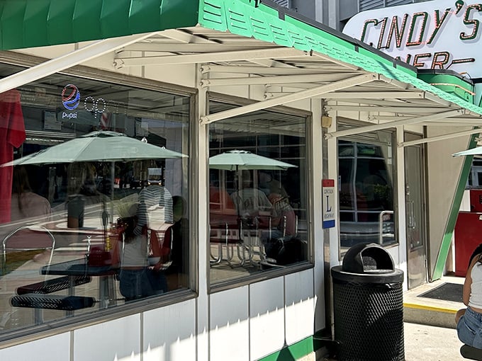 The iconic green-trimmed exterior of Cindy's Diner stands as a beacon of hope for hungry travelers. Fifteen seats of pure culinary magic await inside.