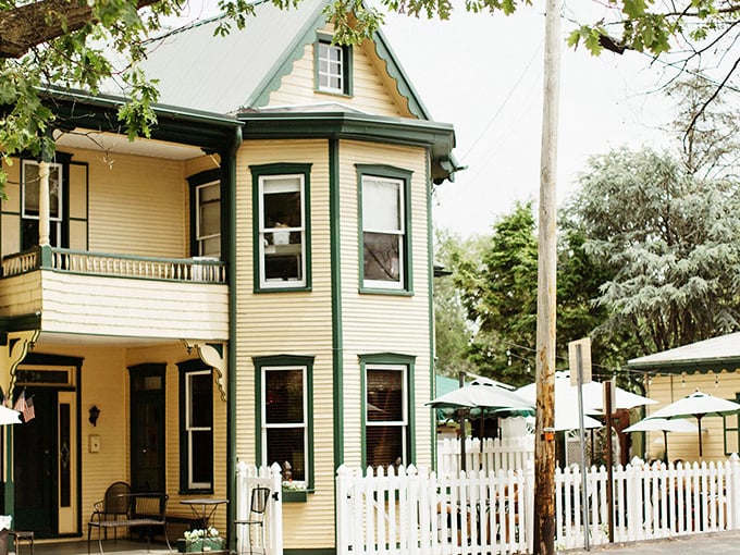 The Victorian charm of Tomato Pie Cafe's yellow exterior with green trim feels like stepping into a storybook where breakfast dreams come true.