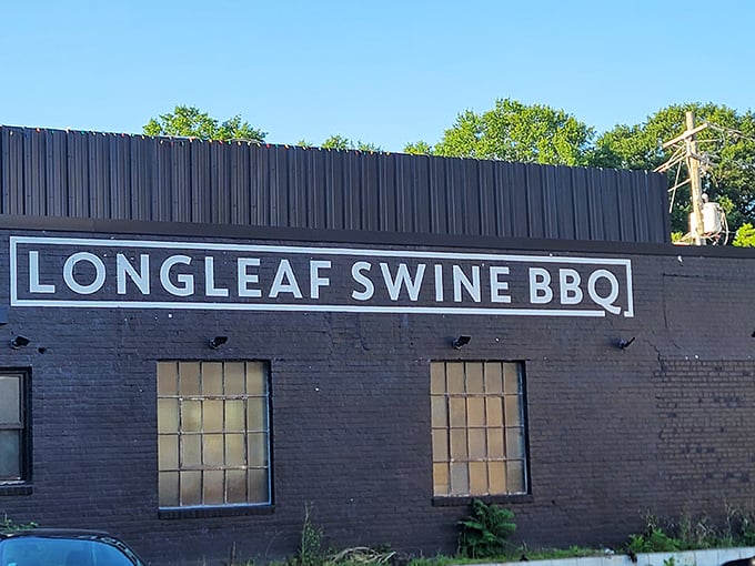 The unassuming black brick exterior of Longleaf Swine is like a secret clubhouse for barbecue aficionados – no flash, all substance.