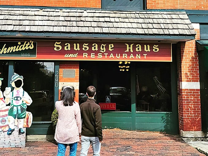 The iconic brick façade of Schmidt's welcomes hungry visitors with its charming wooden awning and German flags—a culinary embassy on Columbus soil.